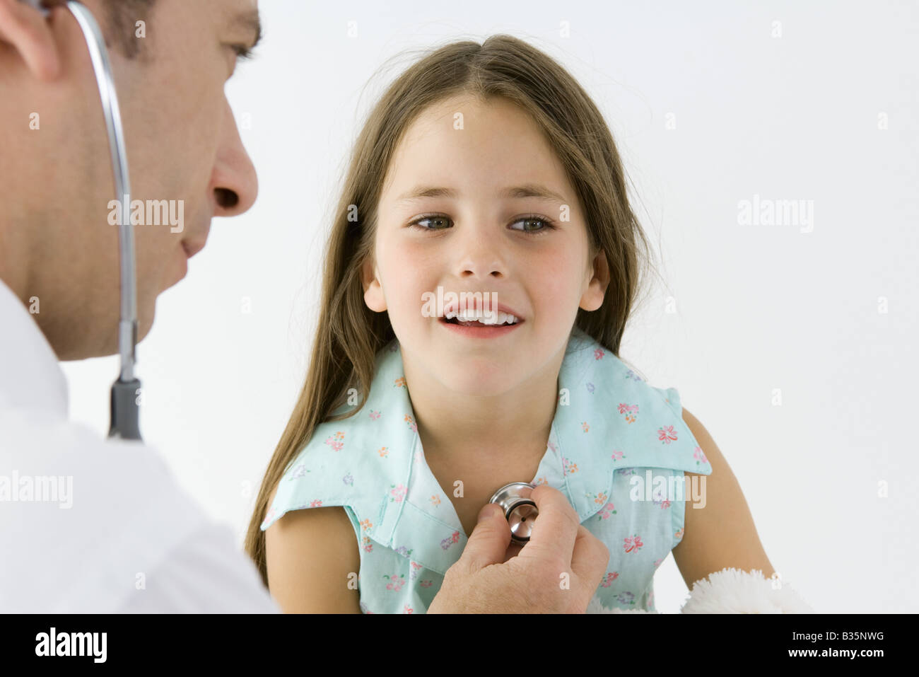 Pédiatre à l'écoute de girl's heart with stethoscope Photo Stock - Alamy