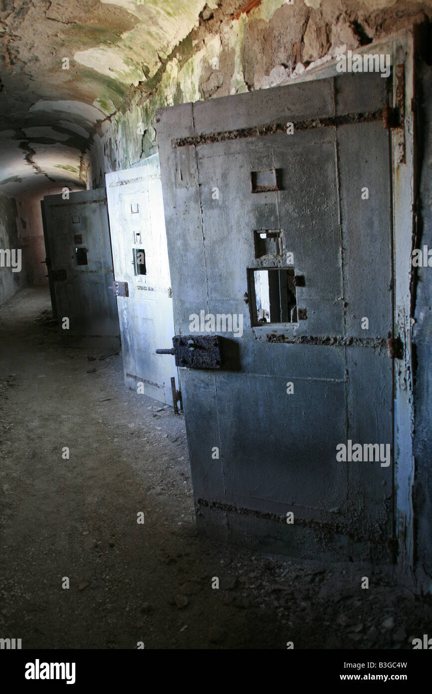 Les portes des cellules de prison isolée dans le corridor noir foncé ...