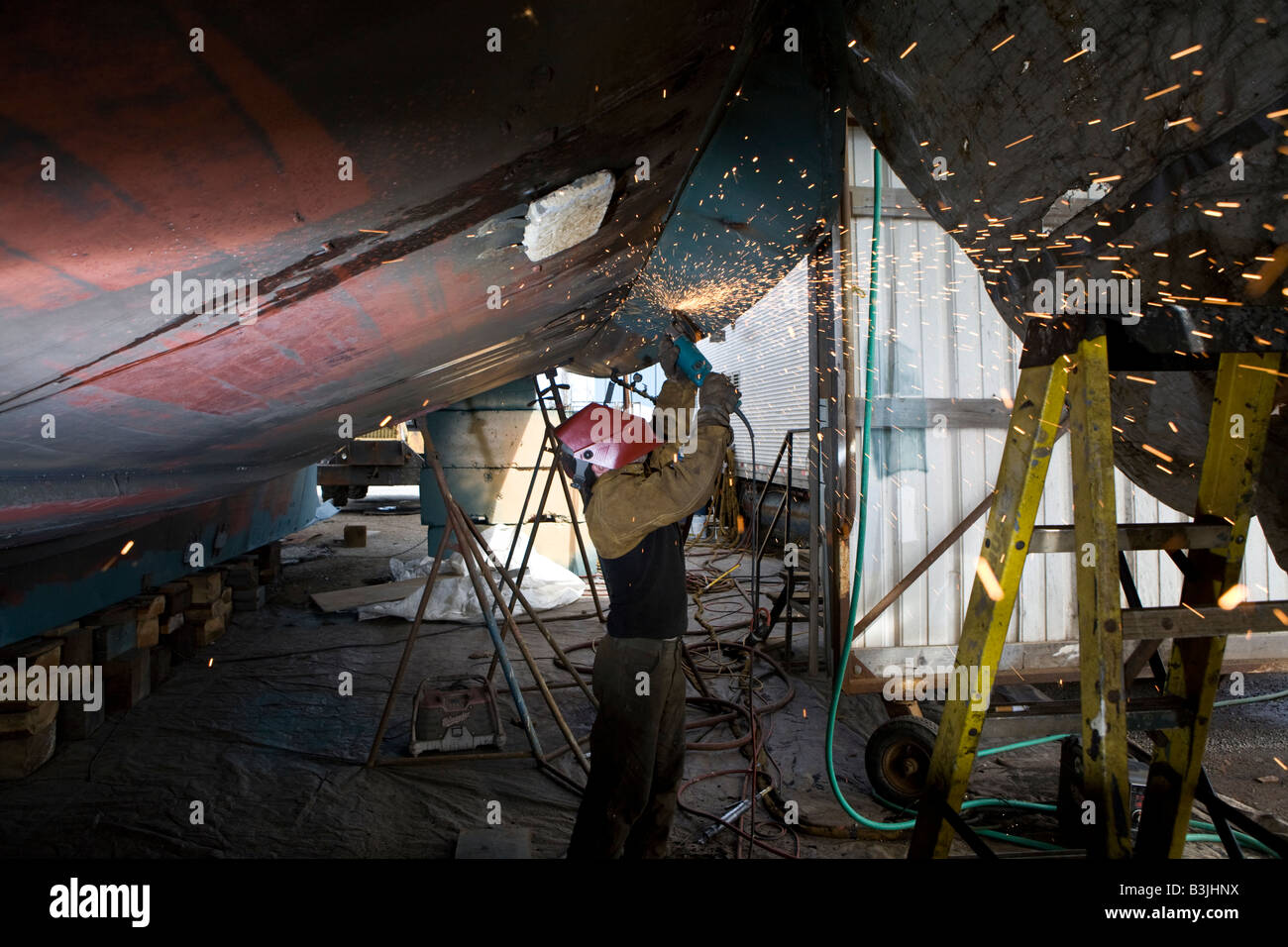 Eric Howe soudures les trous sur le fond d'un bateau de pêche Anna ...