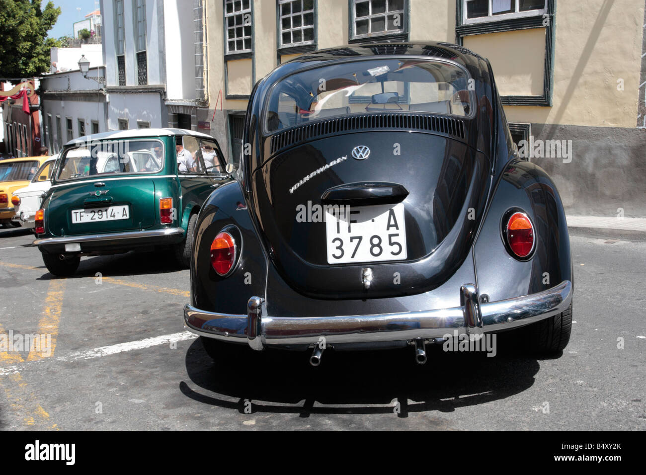 VW Coccinelle noire garée à côté d'une Mini Cooper sur une colline à ...