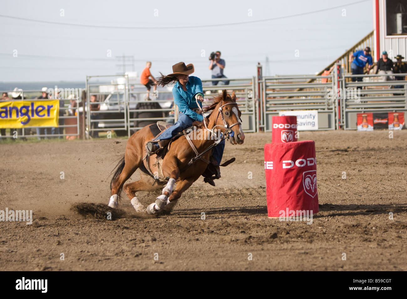 Une course de barils cowgirl autour d'un baril rouge sur un cheval ...