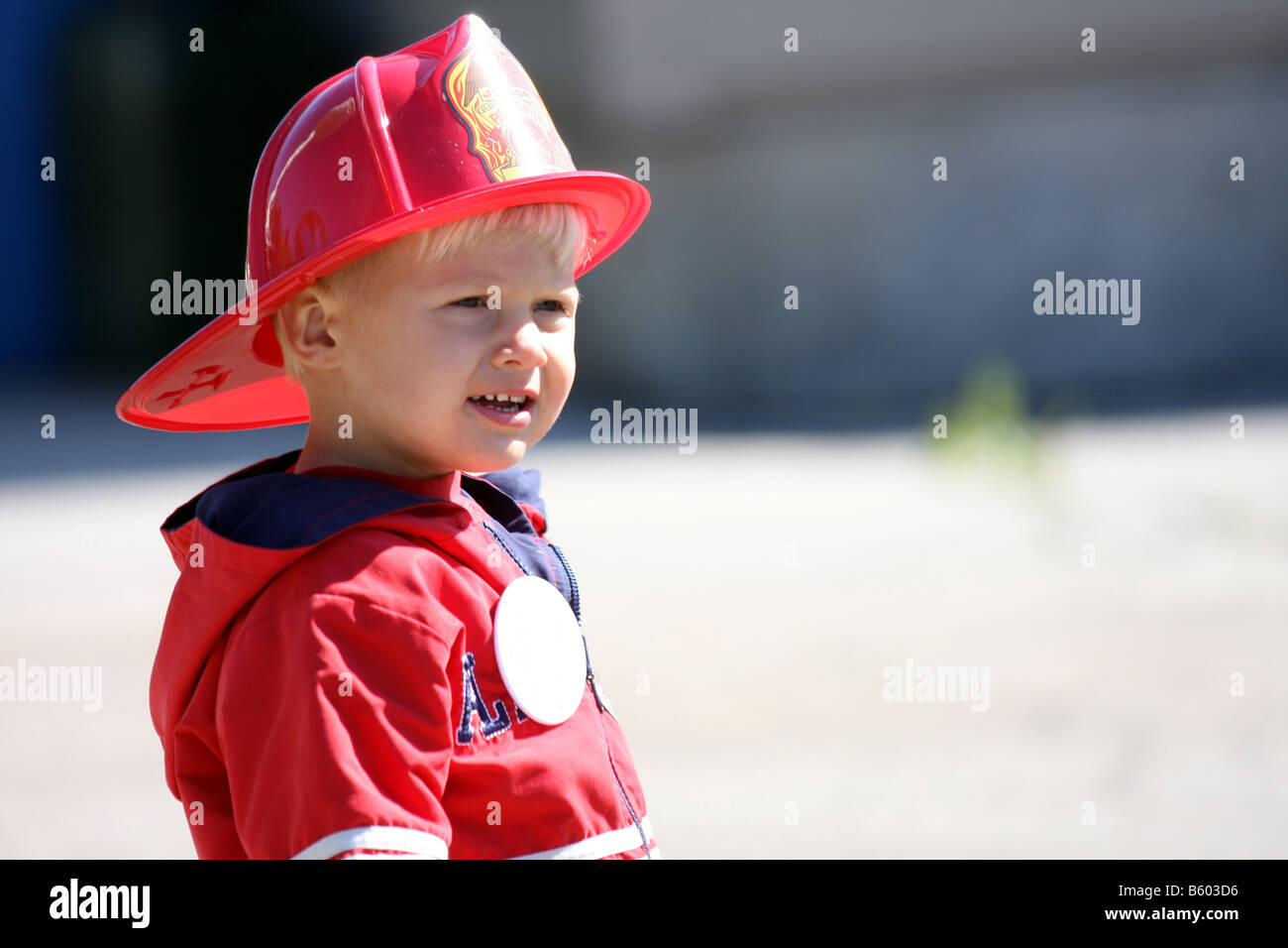 Un petit garçon portant un chapeau ou casque pompiers junior à un salon ...