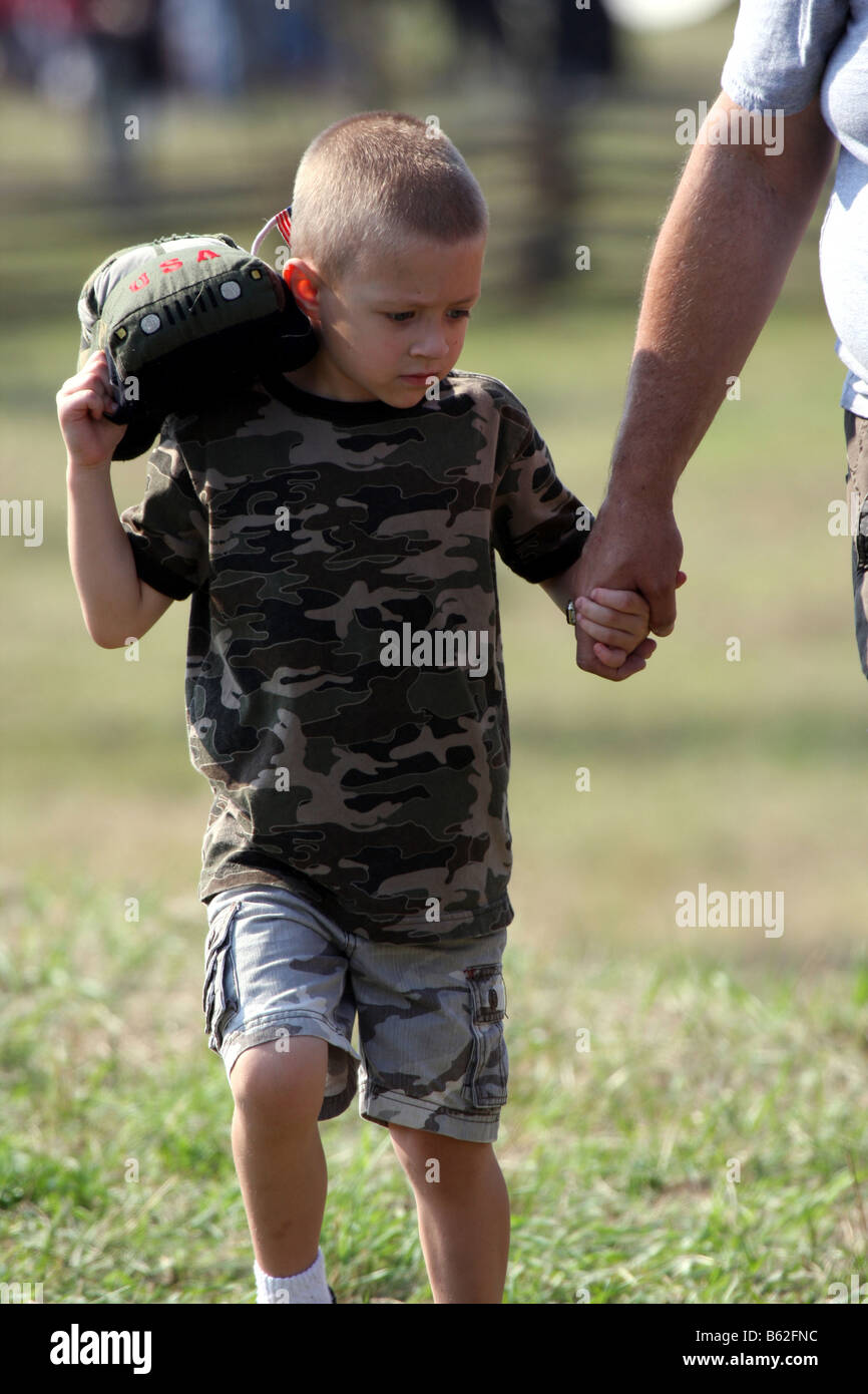 Un petit garçon et son père se tenant la main à une guerre civile de ...