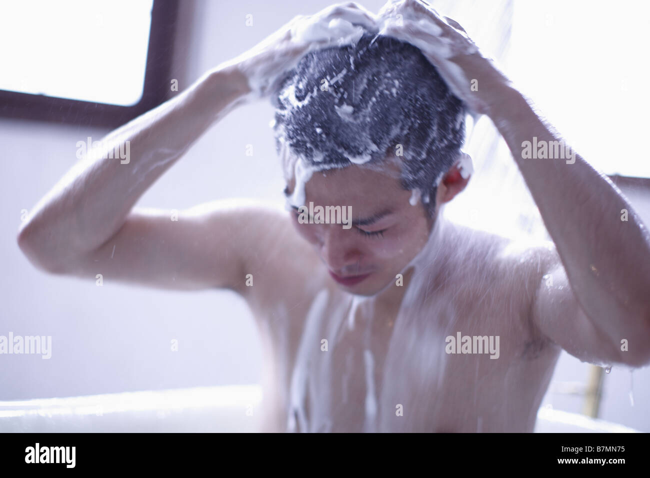 Laver les cheveux de l'homme dans la douche Photo Stock - Alamy