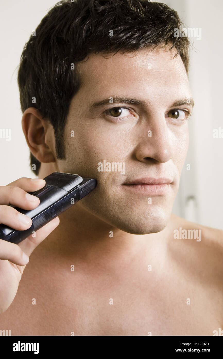 L'homme se rase rasoirs électro-joliment abordé portrait de 20 à 30 ans ...