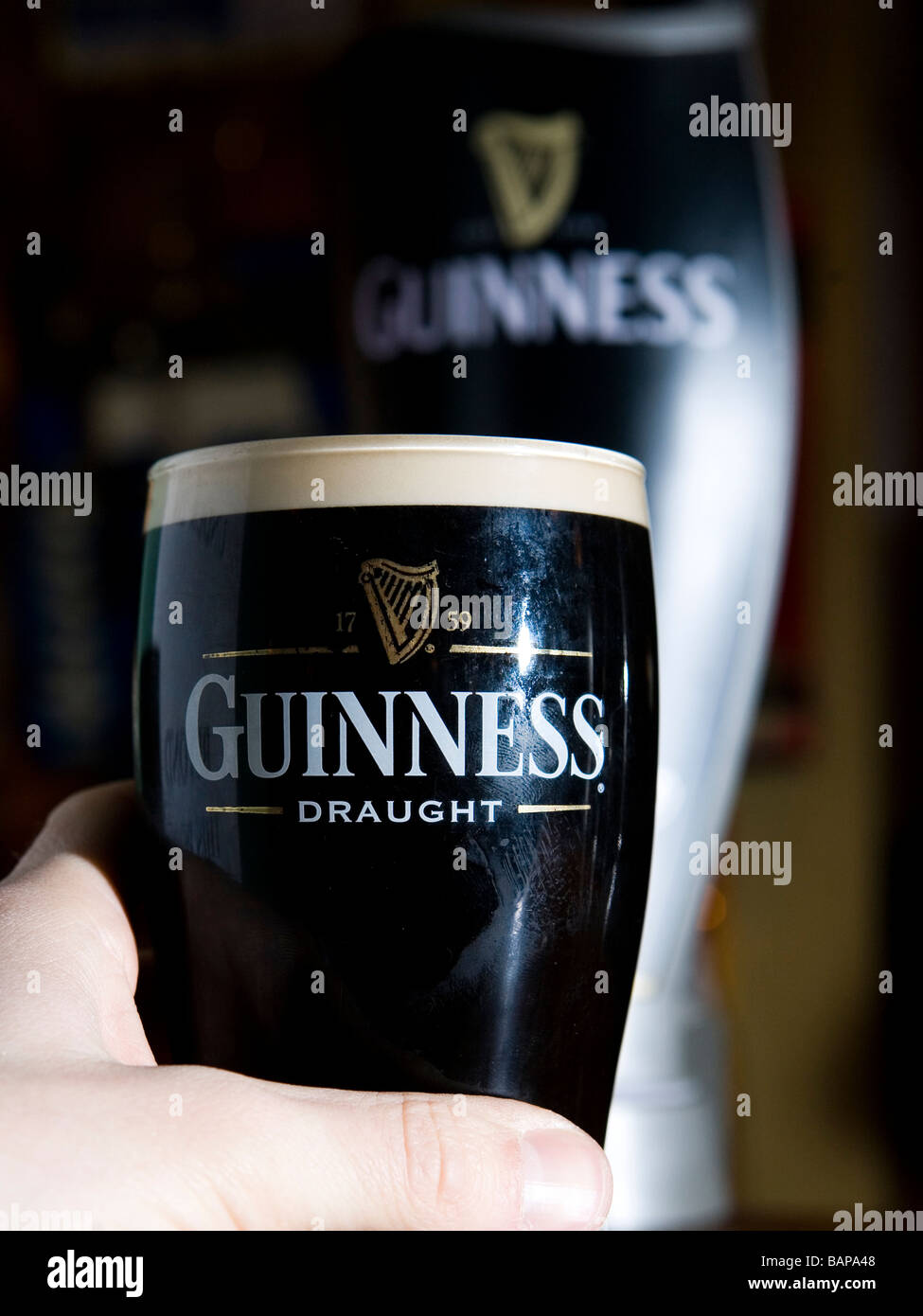 Une pinte de Guinness est tenu à côté de la pompe Photo Stock - Alamy