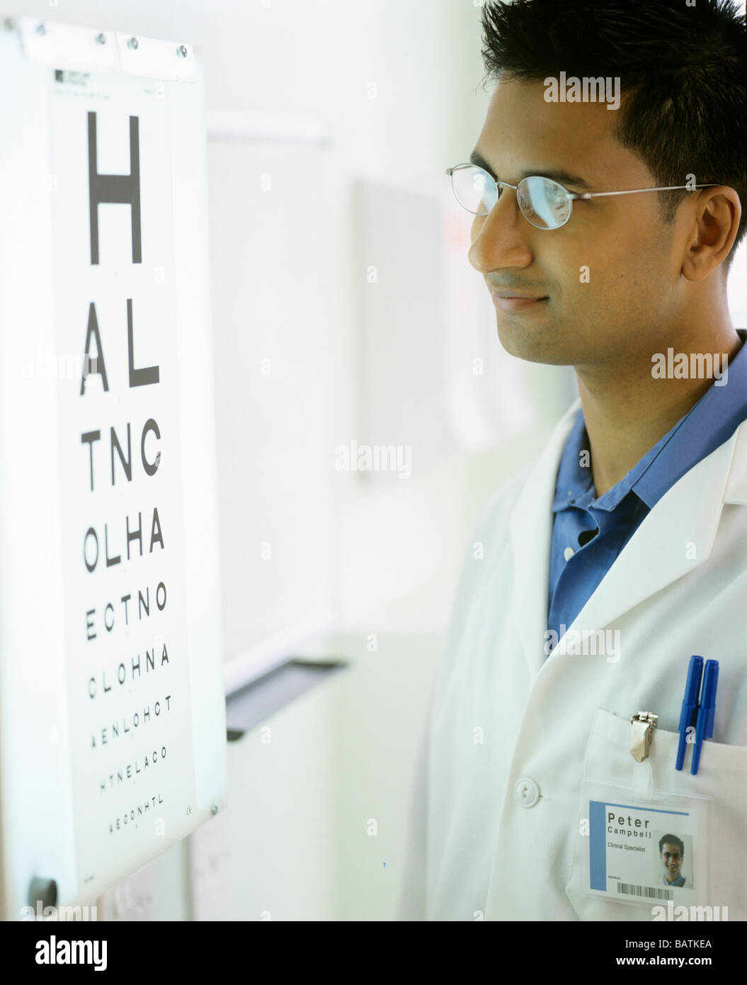Optométriste à côté d'un eyechart. Le tableau est utilisé pour tester l ...