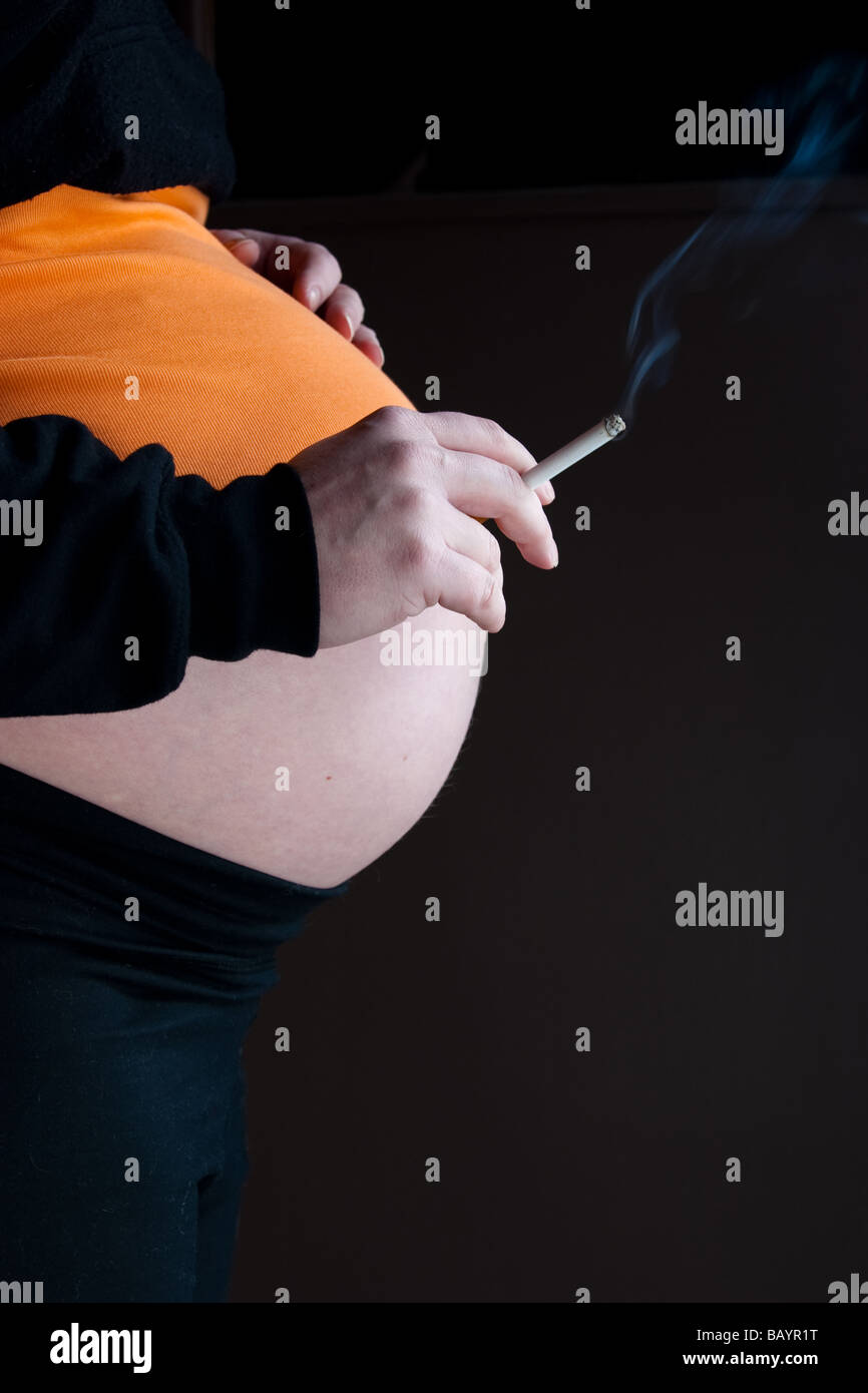 Tourné d'une femme enceinte fumer une cigarette Photo Stock - Alamy