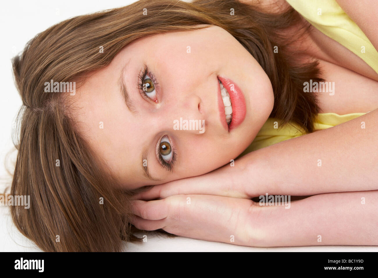 Young Girl Lying On Stomach In Studio Photo Stock - Alamy