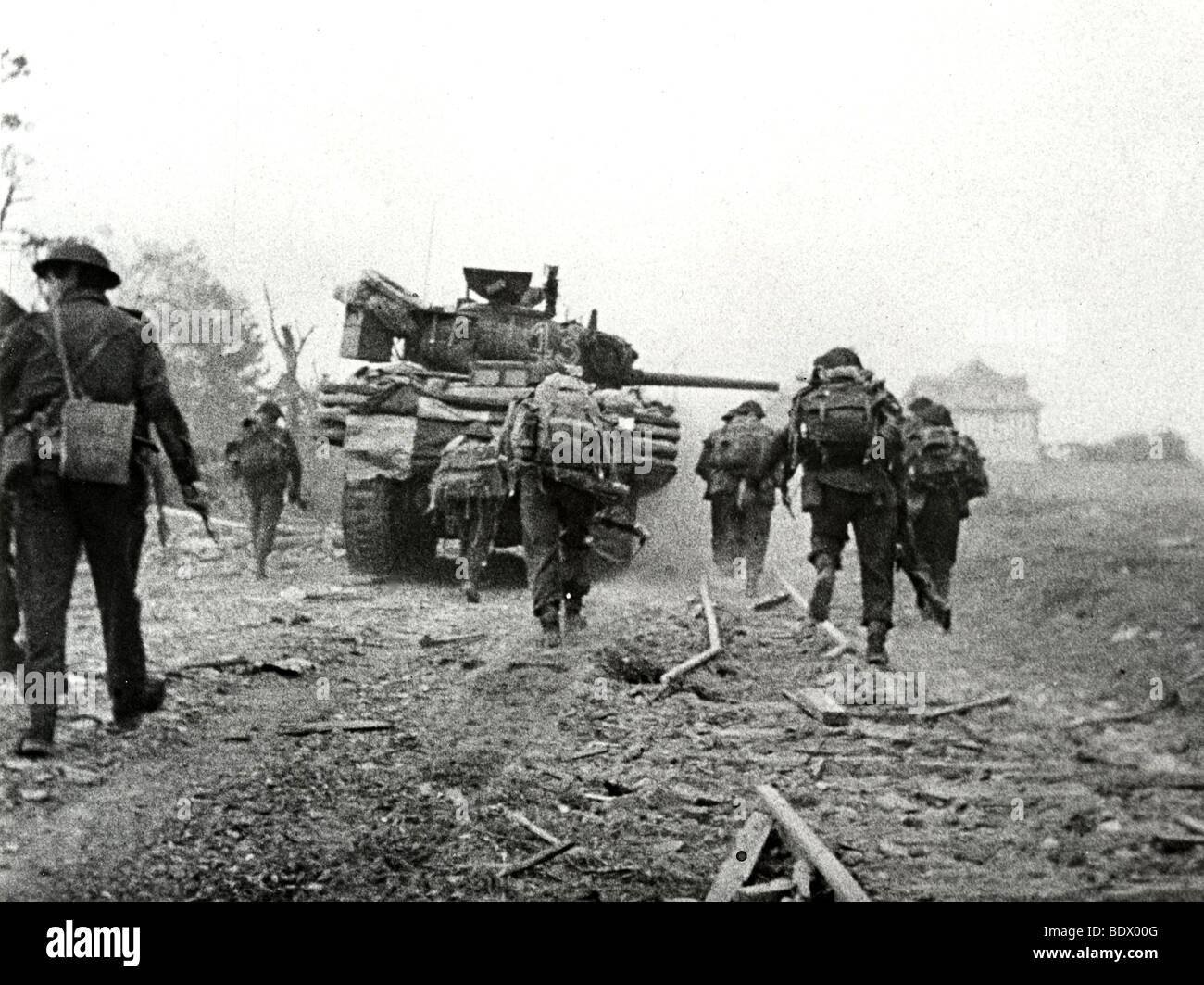 D-Day les troupes britanniques suivez un char Sherman vers un village ...