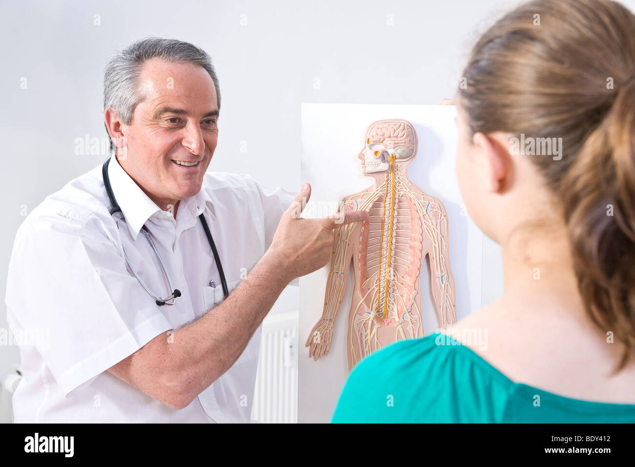 Médecin en expliquant la structure d'un être humain avec un diagramme à ...