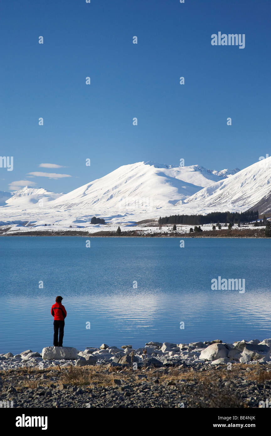 Femme par lac tekapo et deux pouce gamme en hiver Banque de ...