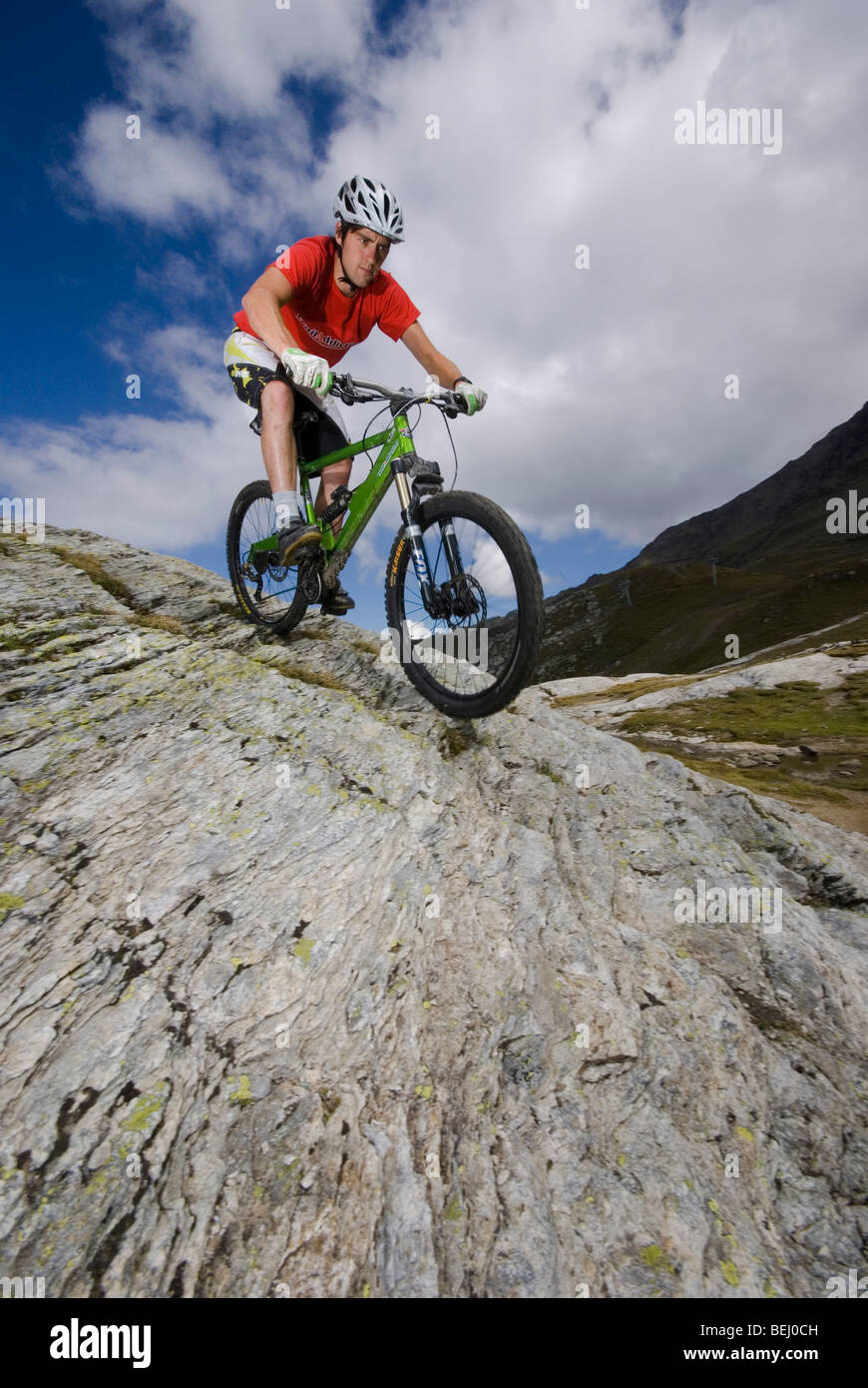 Un vélo de montagne monte un sentier rocheux dans les montagnes près de ...