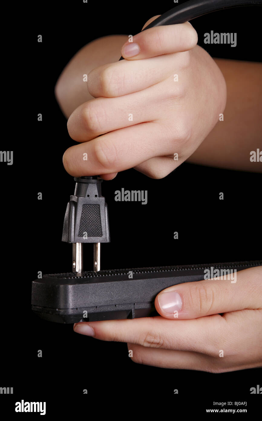 Mains de brancher un câble électrique dans une bande de puissance Photo ...