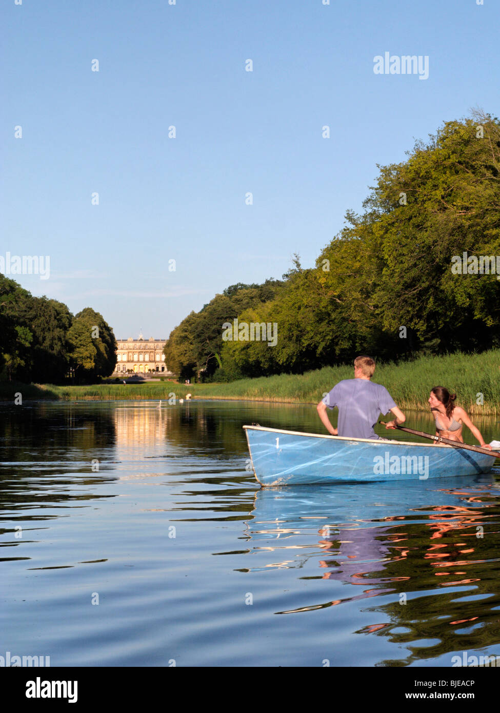 Jeune couple en bateau à rames en face de l'Herren château sur le lac ...