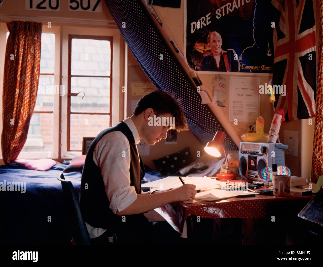 Eton College des années 1980. Un garçon fait ses devoirs dans sa ...