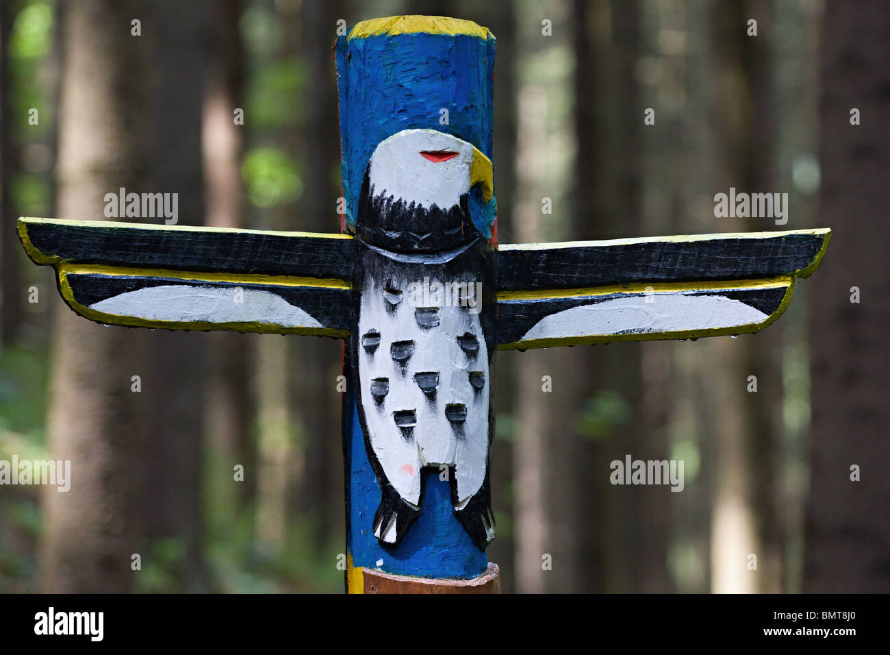 Totem indien avec eagle en forêt Photo Stock - Alamy