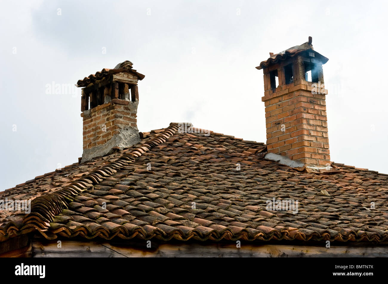 Toit de tuiles d'une vieille maison. La fumée de cheminée Photo Stock ...