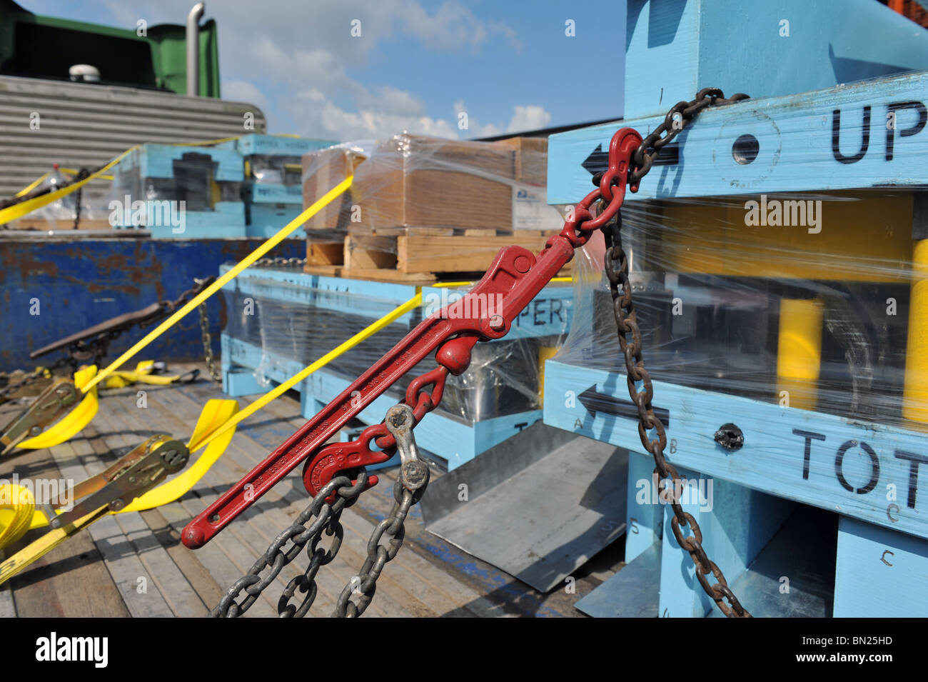 Une chaîne et le binder arrimer le chargement d'une remorque à plateau ...