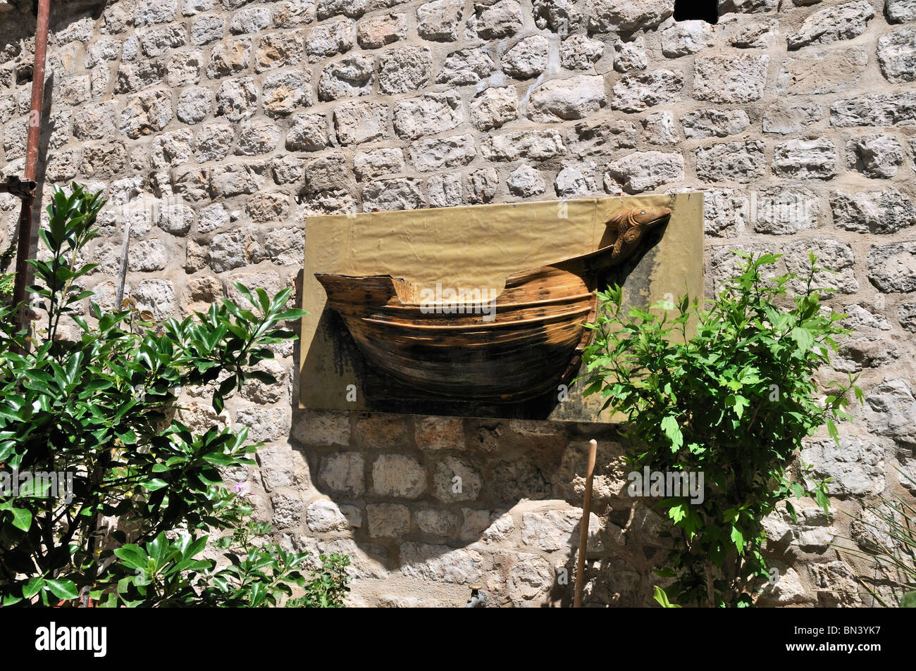 Une plaque d'un ancien navire brun attaché à un mur de pierre dans un ...
