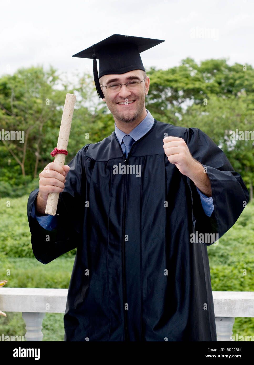 Jeune homme avec graduation cap and gown et diplôme Photo Stock - Alamy
