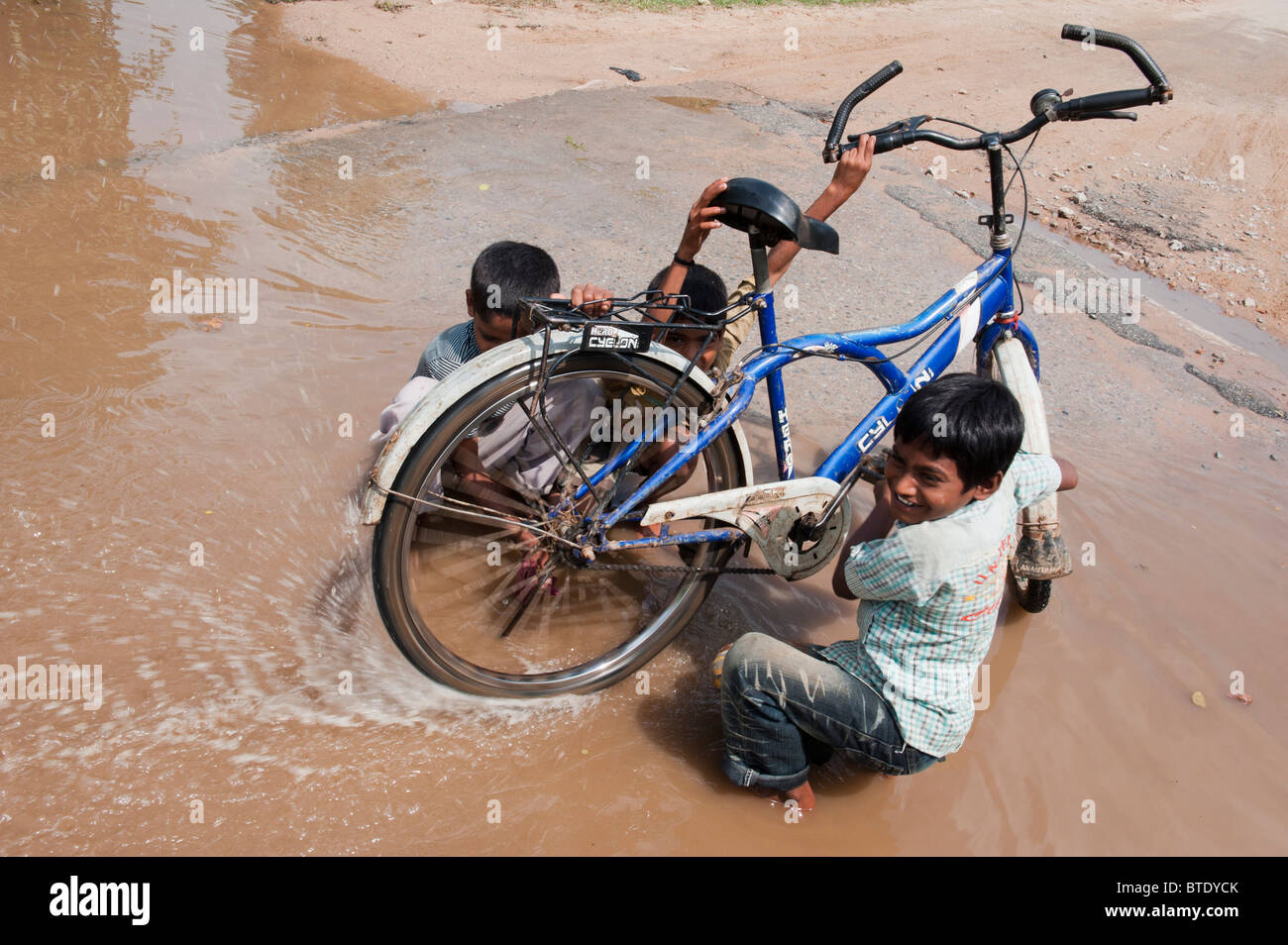 Les jeunes garçons indiens y laver vélo dans un ruisseau en Inde Photo ...