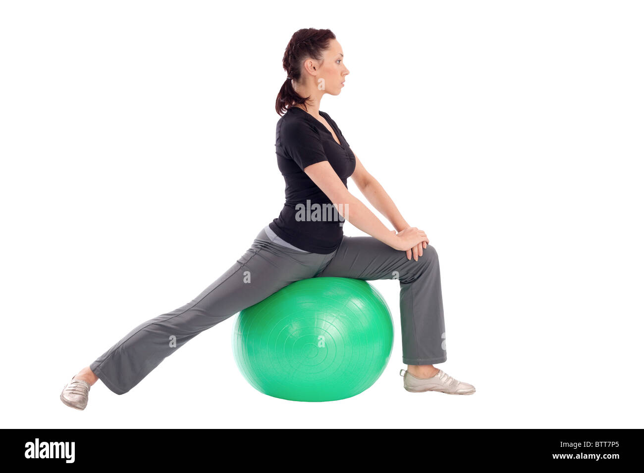 Jeune femme slim avec ballon de gymnastique doing stretching exercice ...