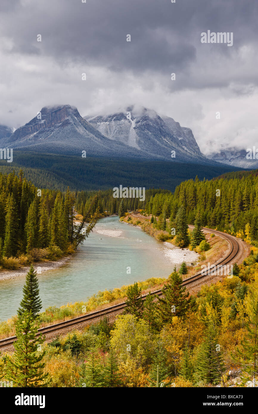 Un train passe par la courbe de Morant dans Bow Valley Parkway avec gamme Bow comme arrière-plan ...