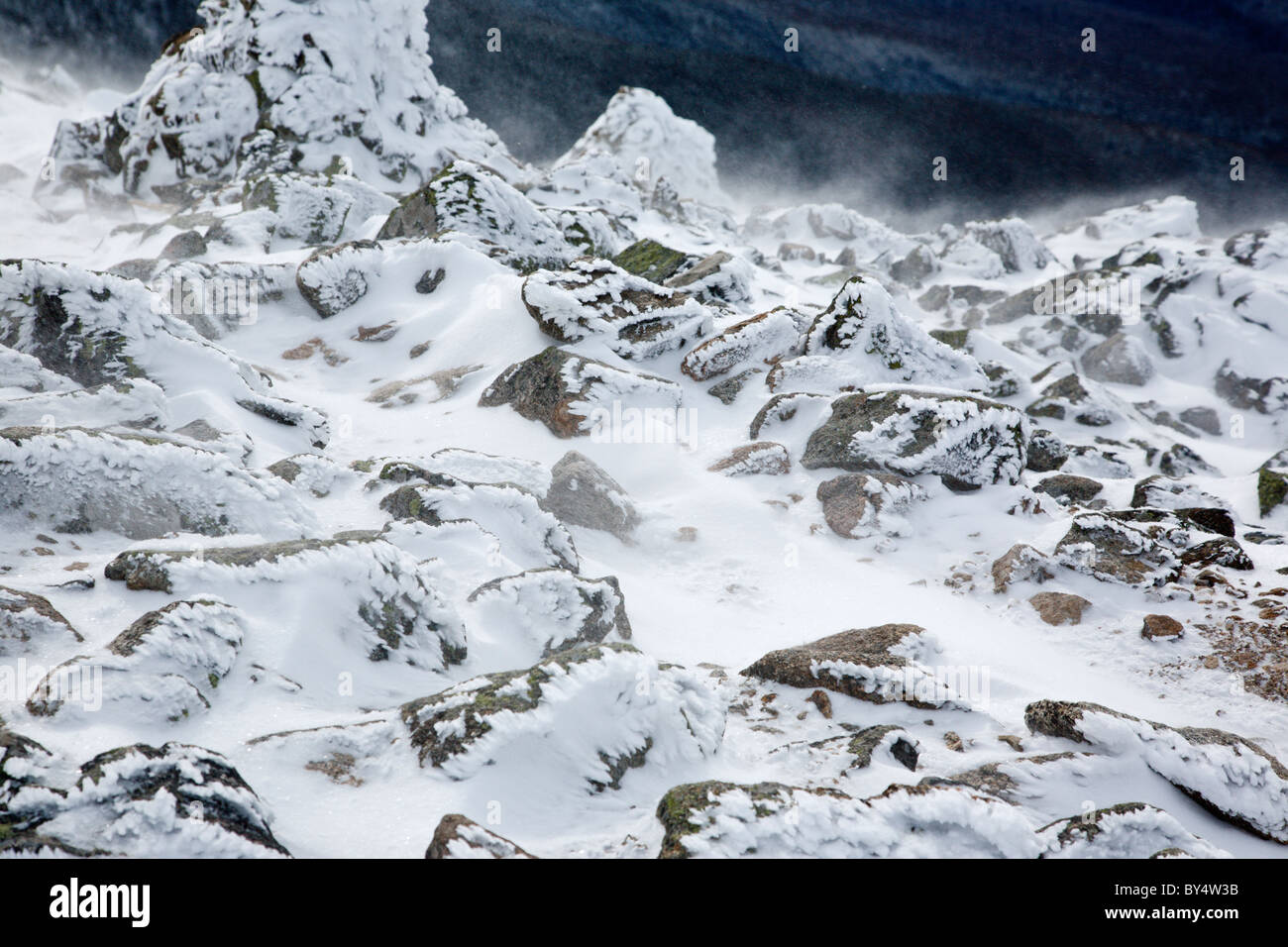 De forts vents soufflent la neige de l'autre côté de la crête du mont ...