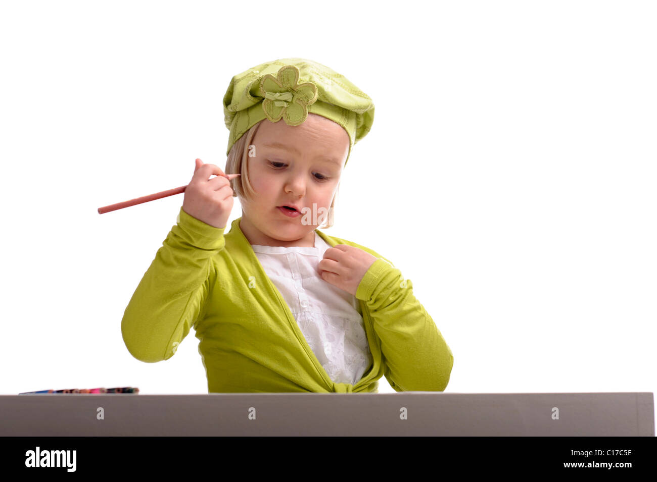 Petite fille en vert le dessin avec des crayons. Isolated on white ...