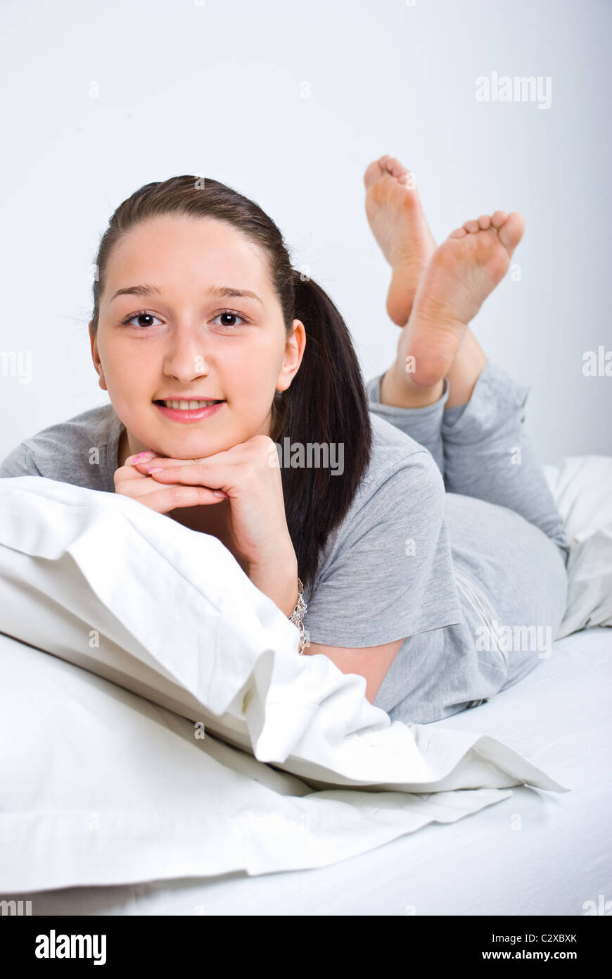 Happy Young Woman Lying Down On Bed Barefoot Photo Stock Alamy