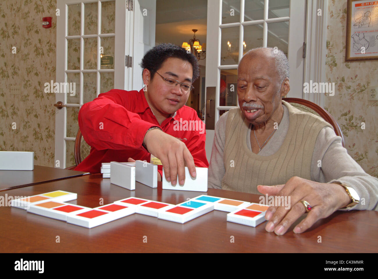 Thérapeute réadaptation aide une personne âgée avec un jeu d'exercice ...