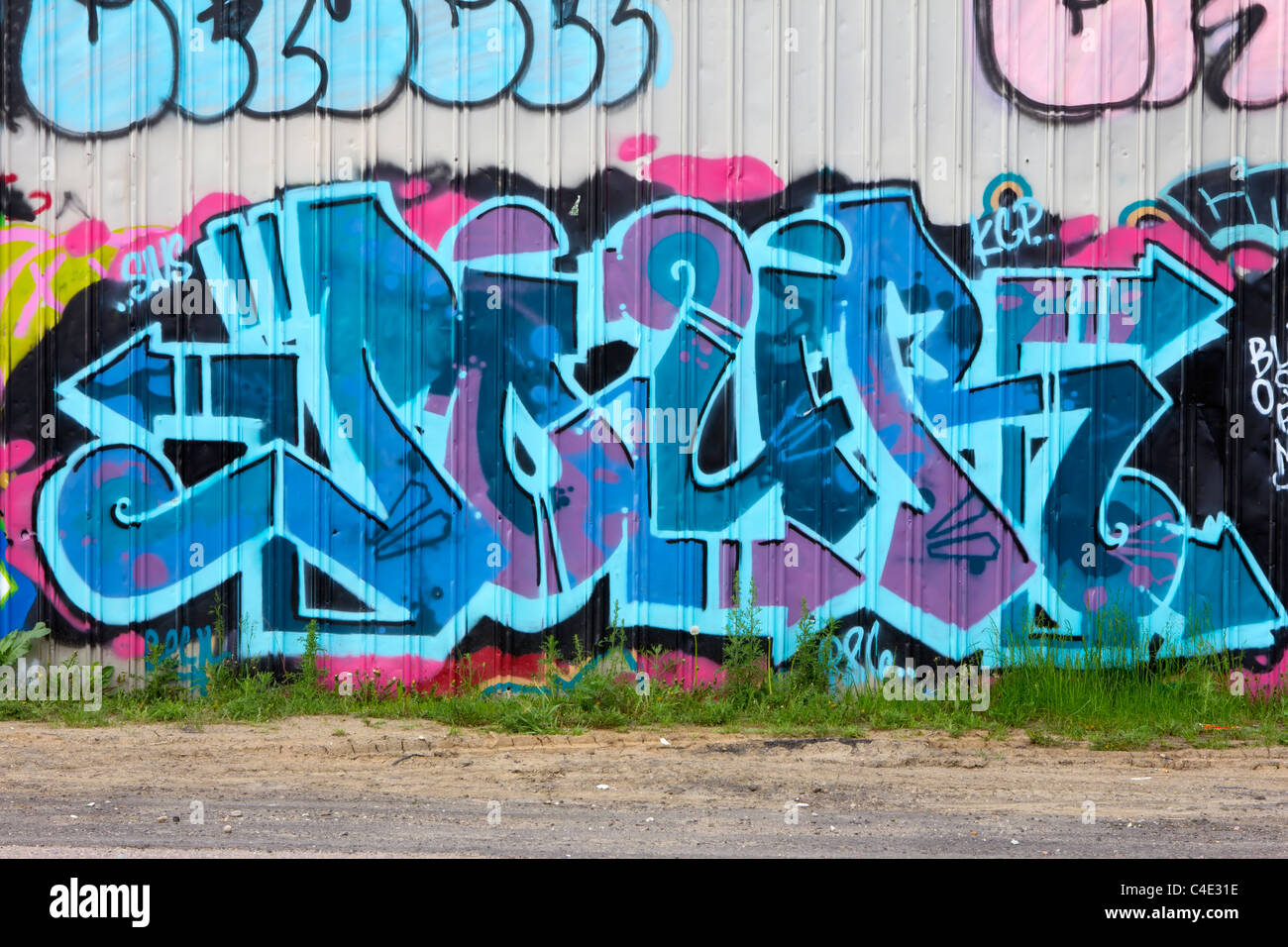 Bleu et Violet Graffiti sur une paroi en acier ondulé au niveau du sol ...