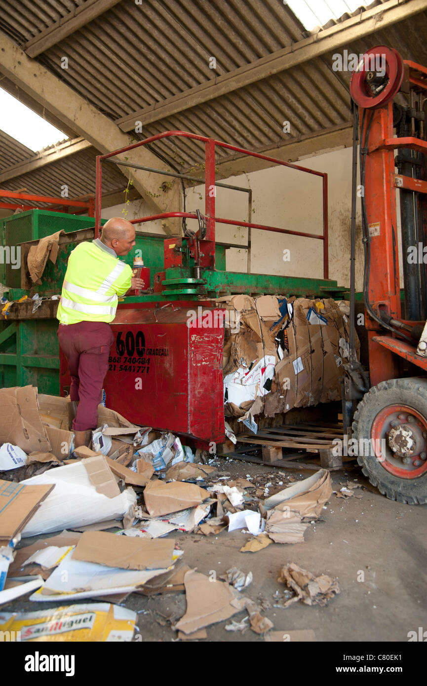 Un travailleur le compactage de carton déchets en balles prêt pour le ...