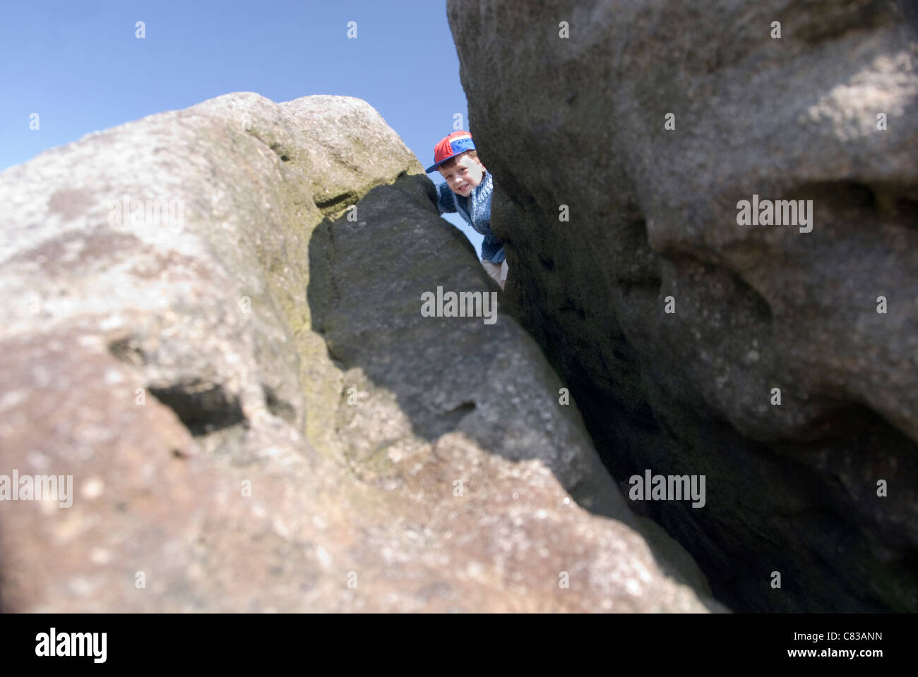 Petit garçon avec un pic si fissure dans Giant Boulder Rock le haut de ...