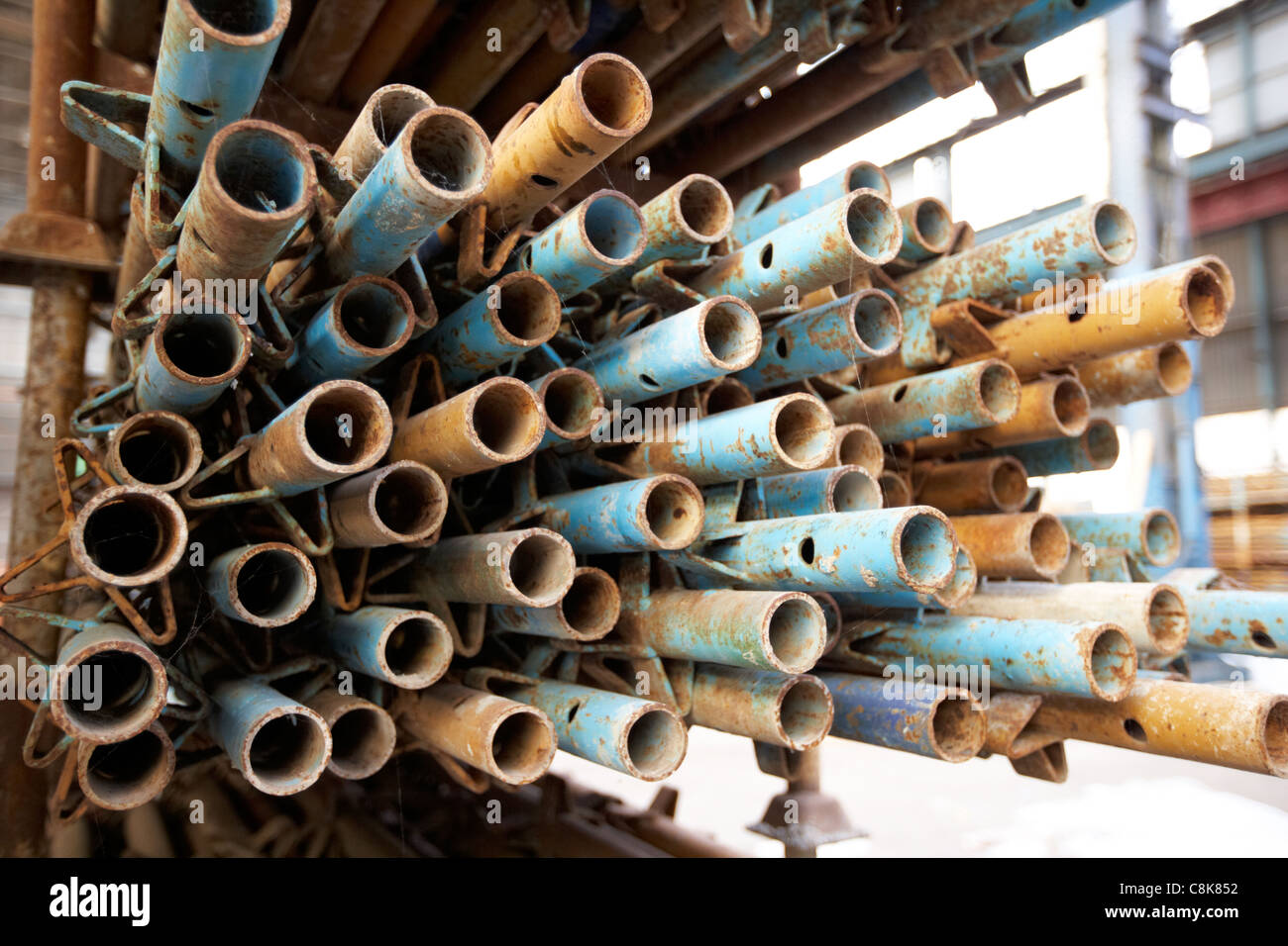 Pile de poteaux d'échafaudage utilisé stocké dans une vieille usine ...