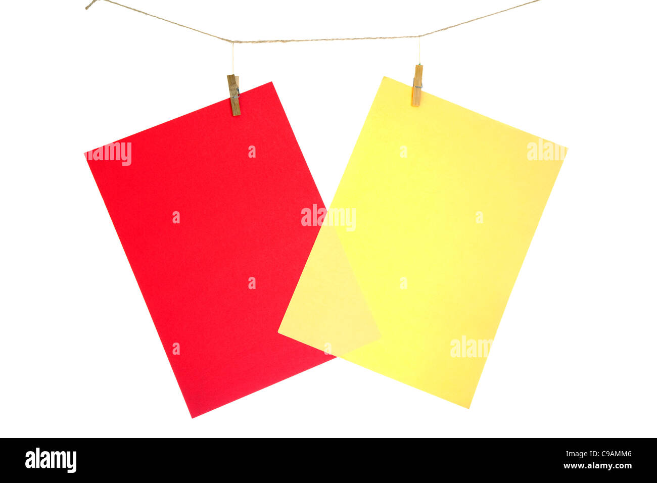Feuille de papier rouge et jaune sur une corde à linge. Isolé sur fond ...