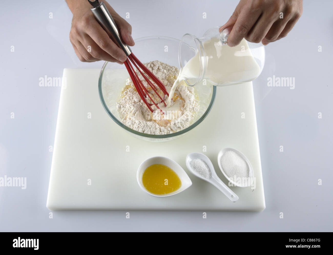 Verser le lait et le mélange de farine et d'œufs Photo Stock - Alamy