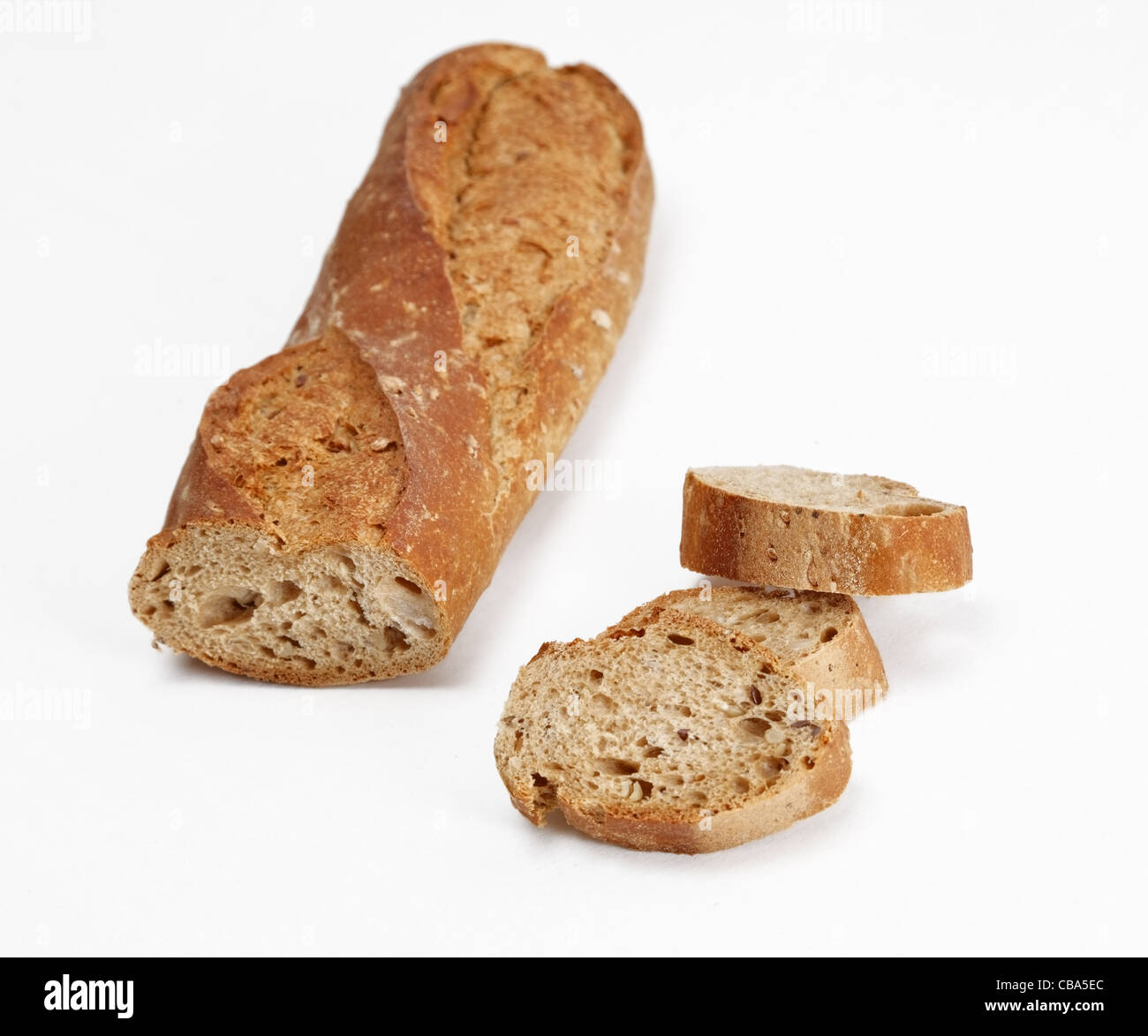Une moitié d'une baguette de pain complet et trois morceaux sur un fond ...