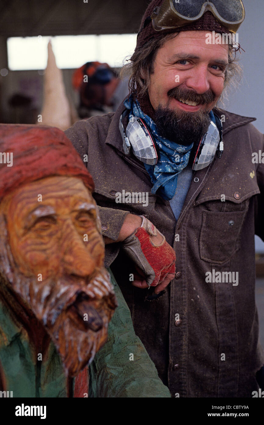 Sculpteur sur bois debout à côté d'une de ses créations smiling ...