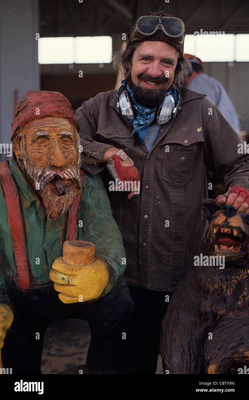 Sculpteur sur bois debout à côté d'une de ses créations smiling ...