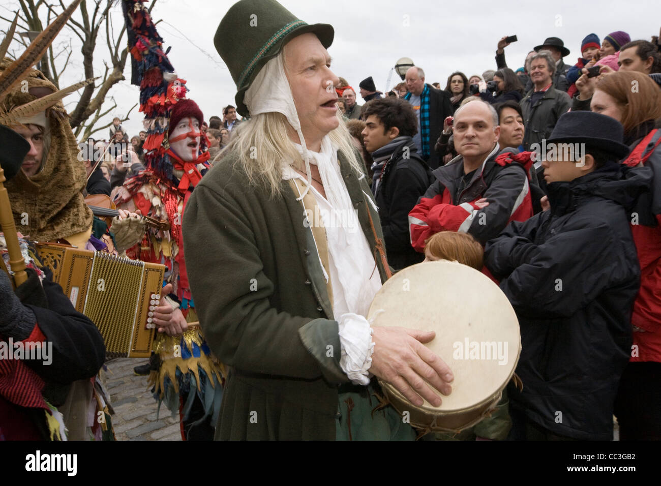 Un acteur en costume bat un tambour pendant un folklore traditionnel ...