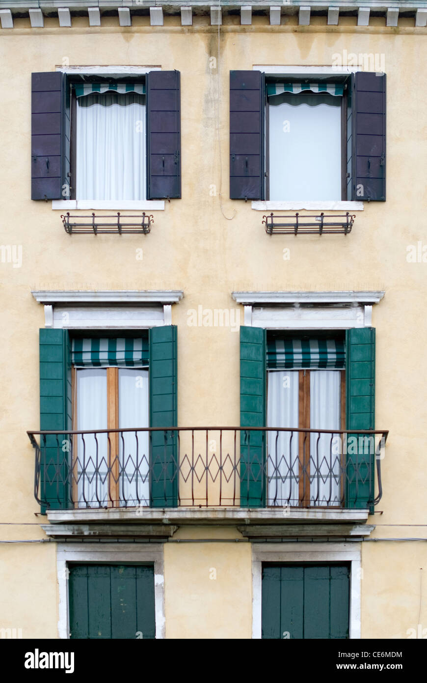 La façade d'une maison, avec des volets aux fenêtres et un balcon ...