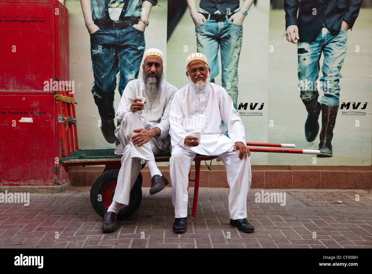 Deux hommes arabes assis sur leur brouette ayant un chat et une tasse ... Deux hommes arabes assis sur leur brouette ayant un chat et une tasse ...