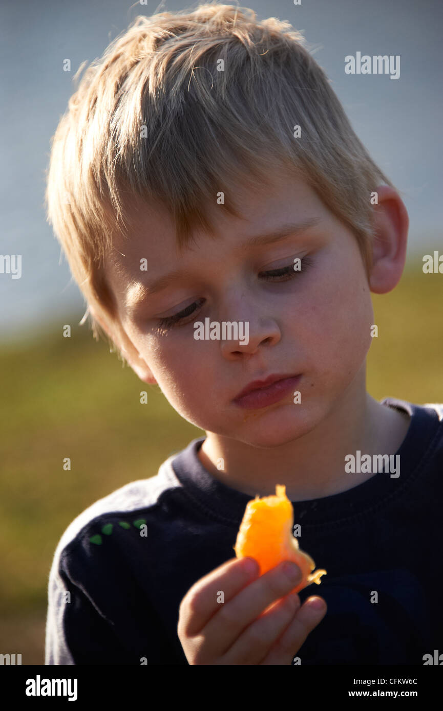 Garçon mange une orange Banque de photographies et d’images à haute ...