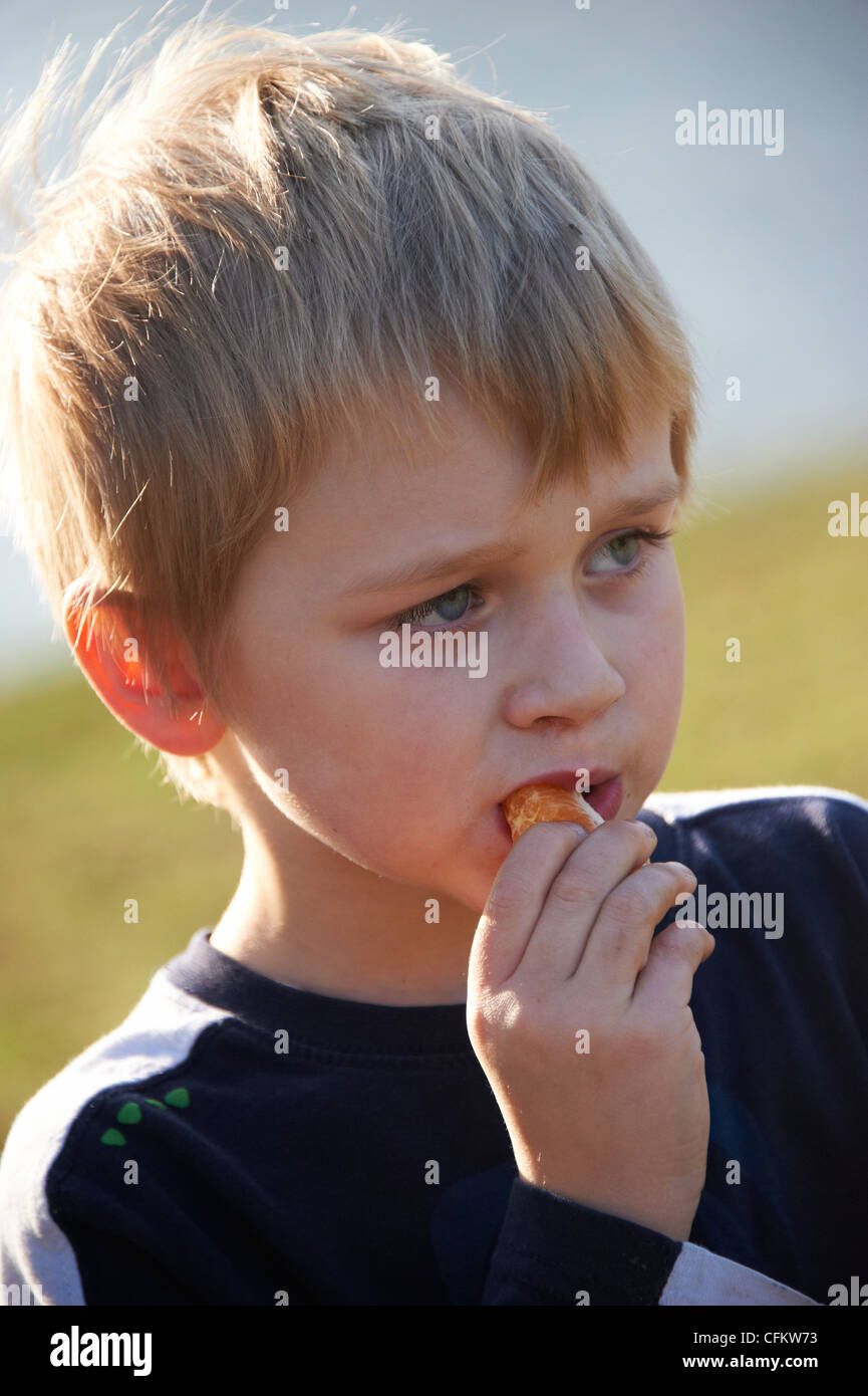 Garçon mange une orange Banque de photographies et d’images à haute ...
