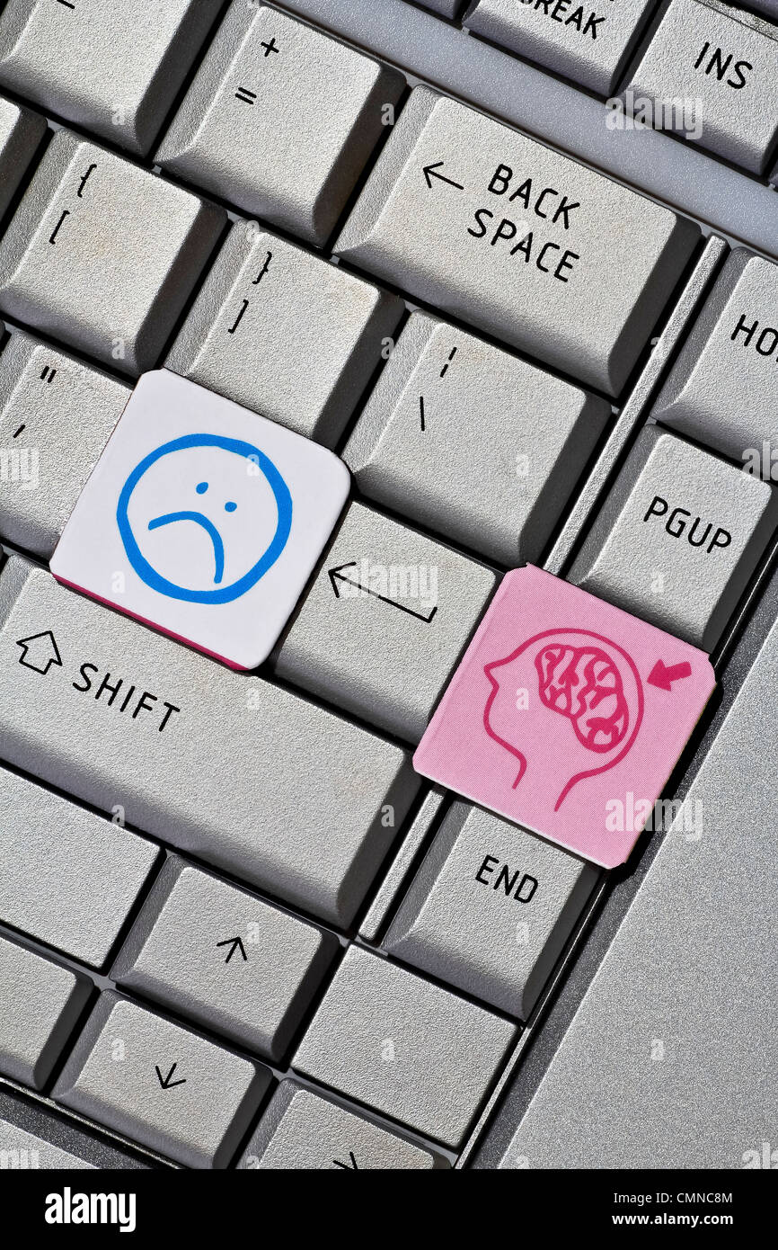 Clavier de l'ordinateur avec visage triste et symbole du cerveau Photo ...