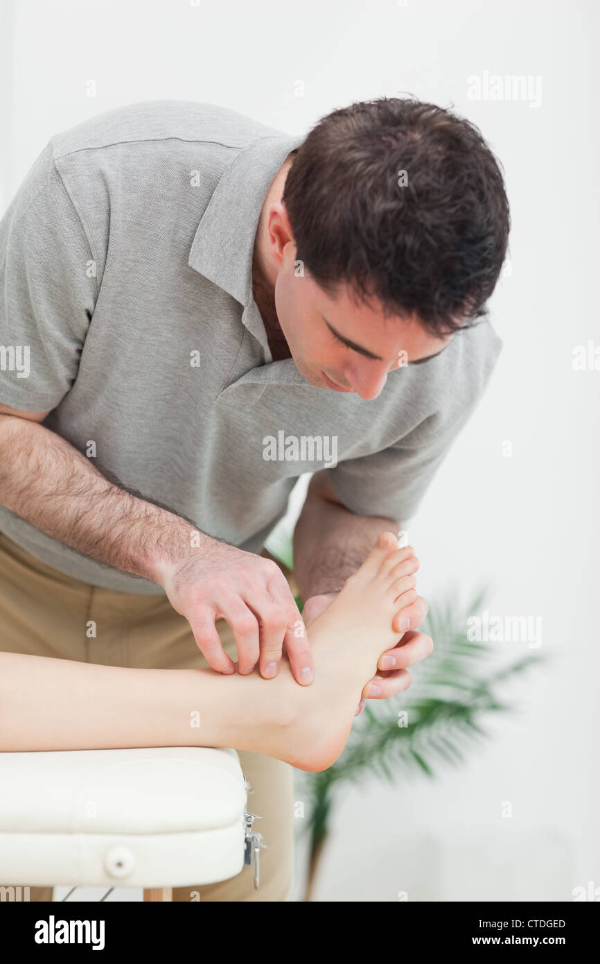 Podiatre examinant le pied d'un patient Photo Stock - Alamy