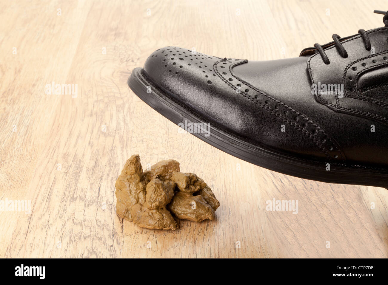 Une chaussure noire mans sur le point d'étape sur une merde de chien ...