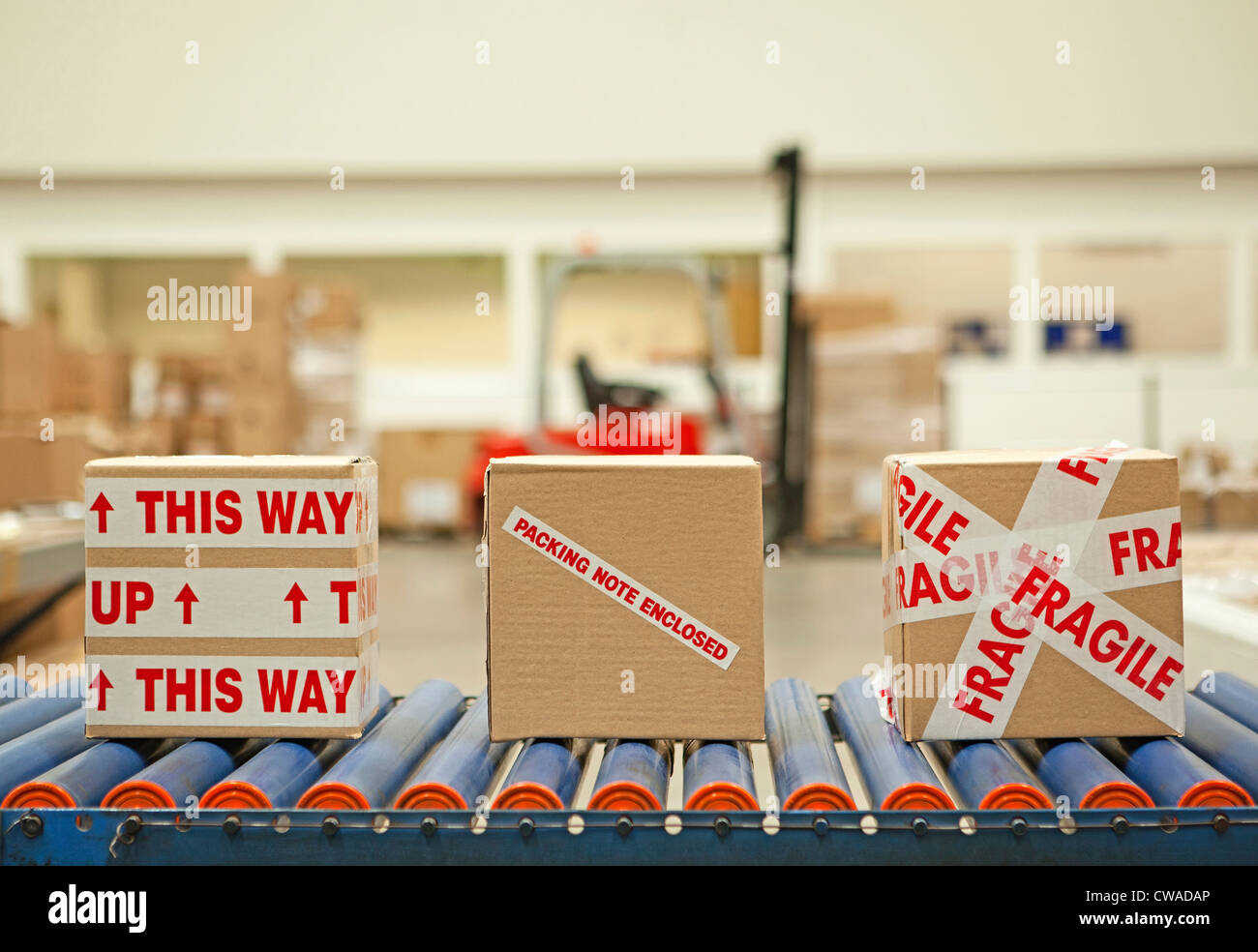 Trois boîtes en carton avec du ruban sur la courroie du convoyeur de ...